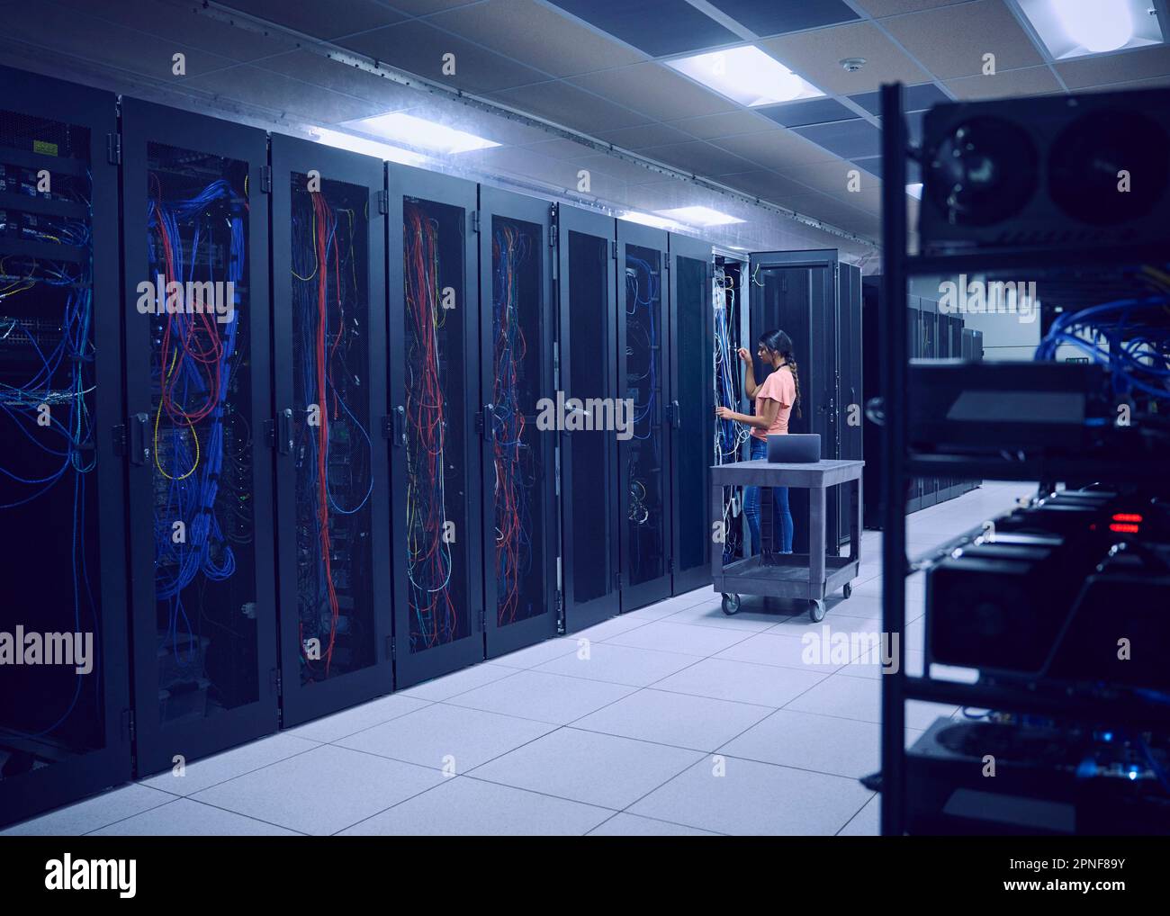 Female technician working in server room Stock Photo - Alamy