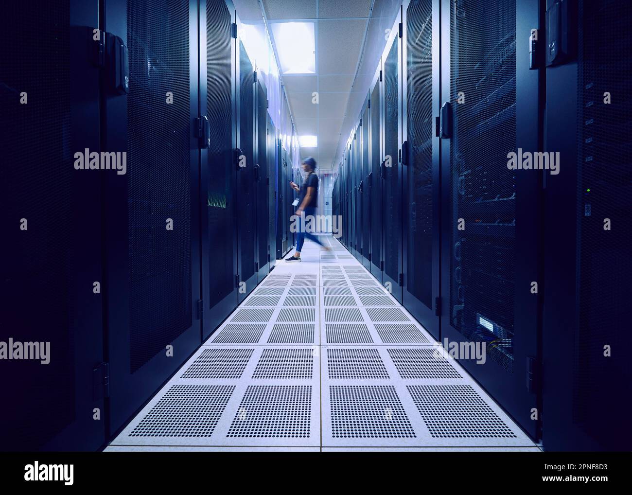 Female technician walking in server room Stock Photo - Alamy