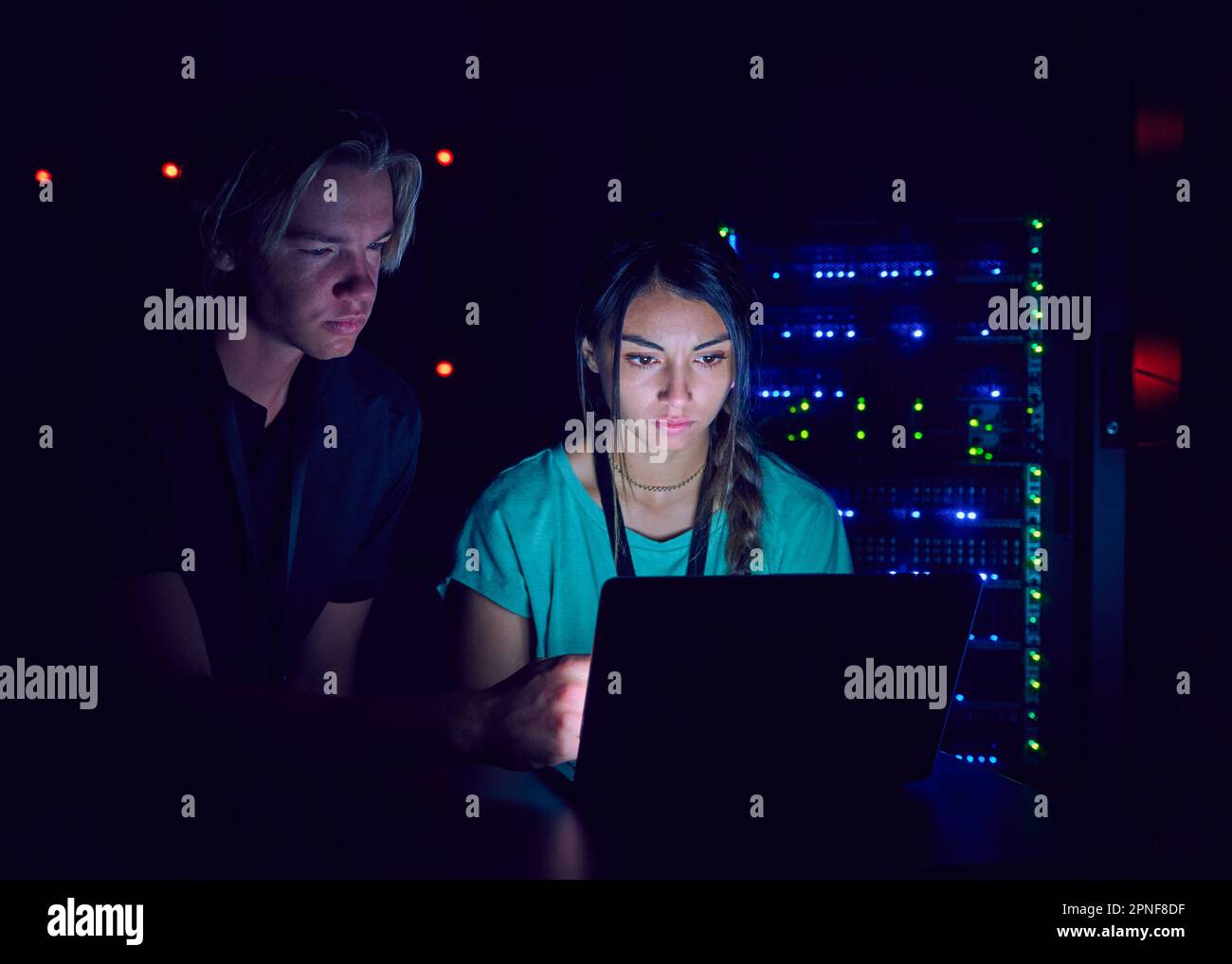 Technicians using laptop in server room Stock Photo - Alamy