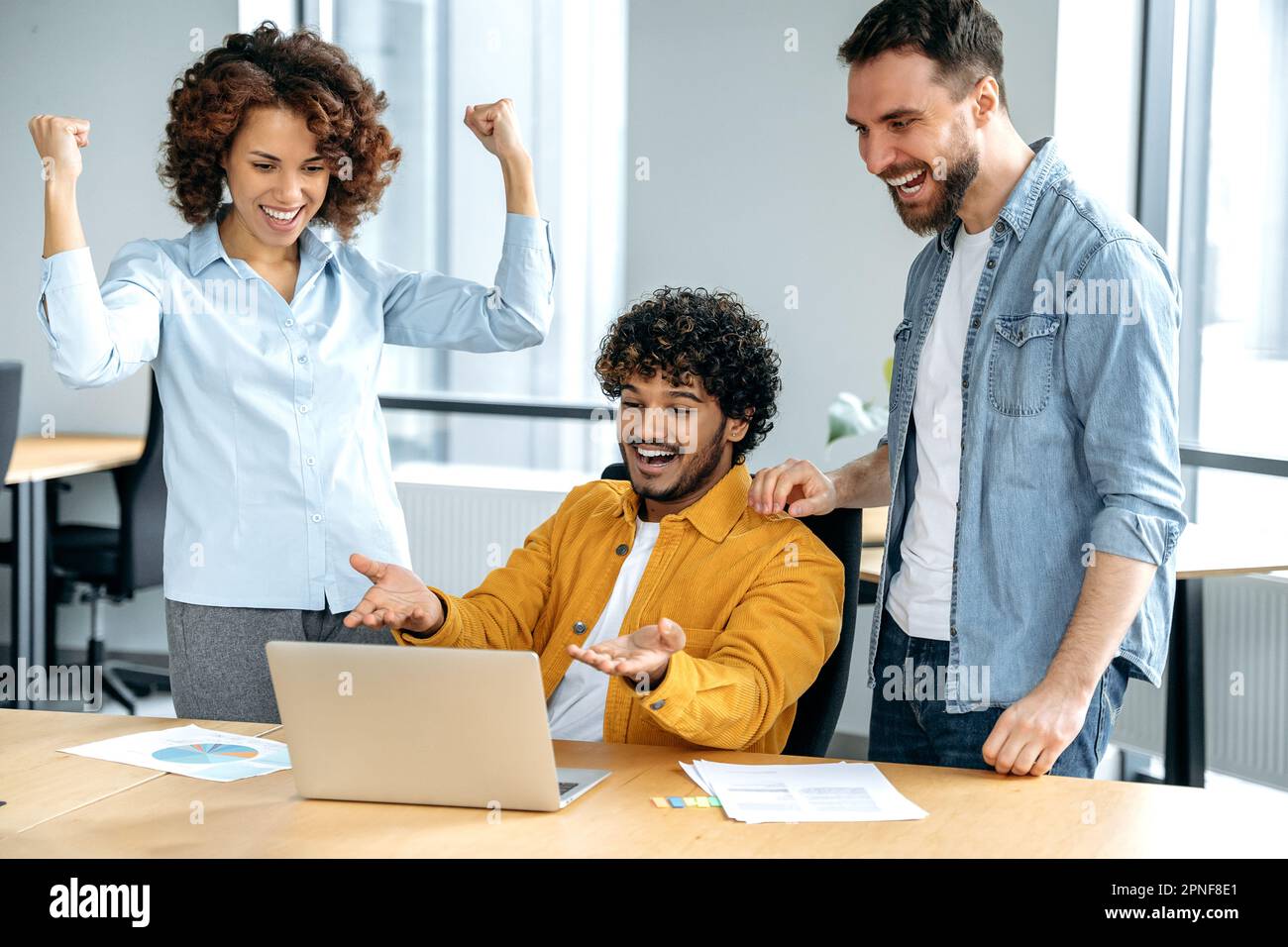 Good news. Multiracial colleagues of the company work together in the ...