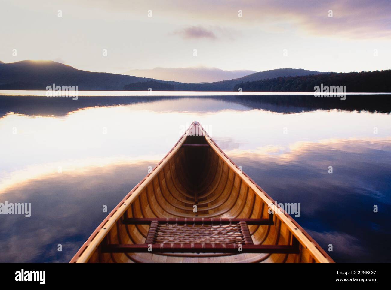 United States, New York, St. Armand, Lake Placid, Canoe in morning mist ...
