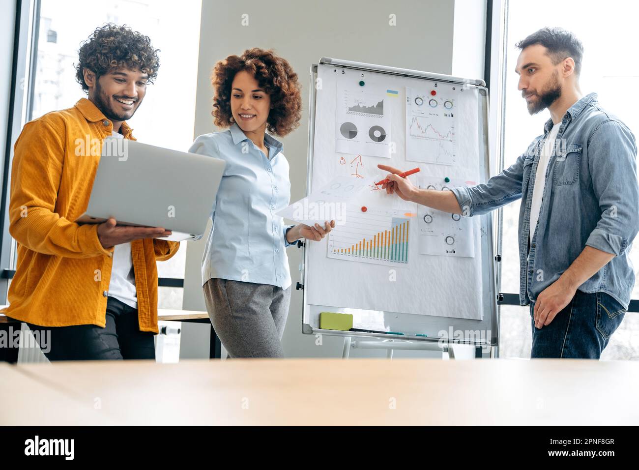 Group brainstorm in boardroom. Group of positive multiracial colleagues ...