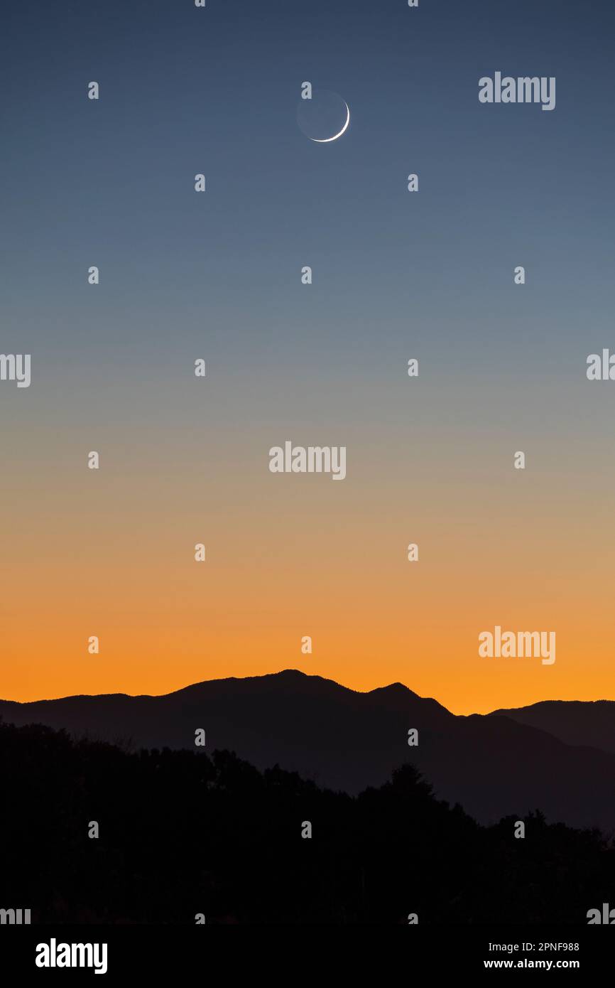 United States, New Mexico, Santa Fe, Crescent moon over Jemez Mountains ...