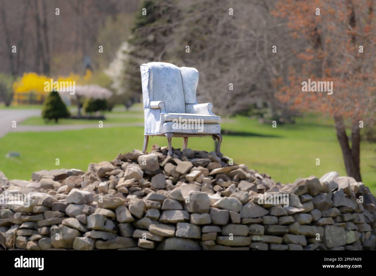 Funny, strange wingback tapestry chair sitting on a stacked rock podium ...