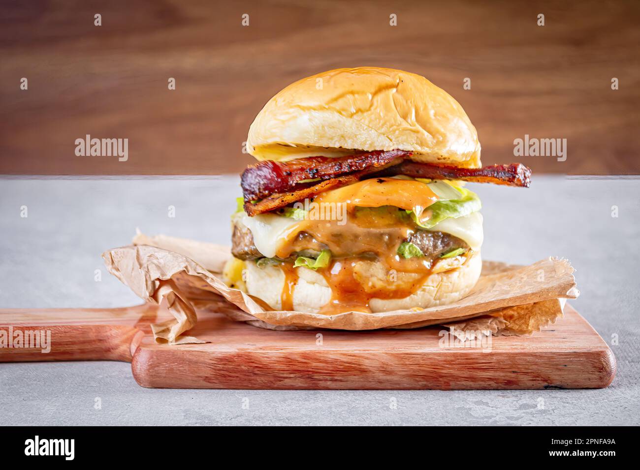 Delicious hamburger with cheddar cheese, bacon and dripping sauce; over ...