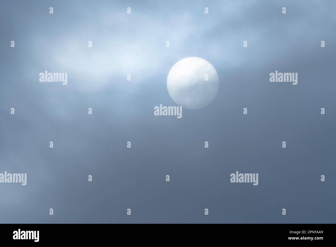 Hazy sun behind wispy clouds Stock Photo - Alamy