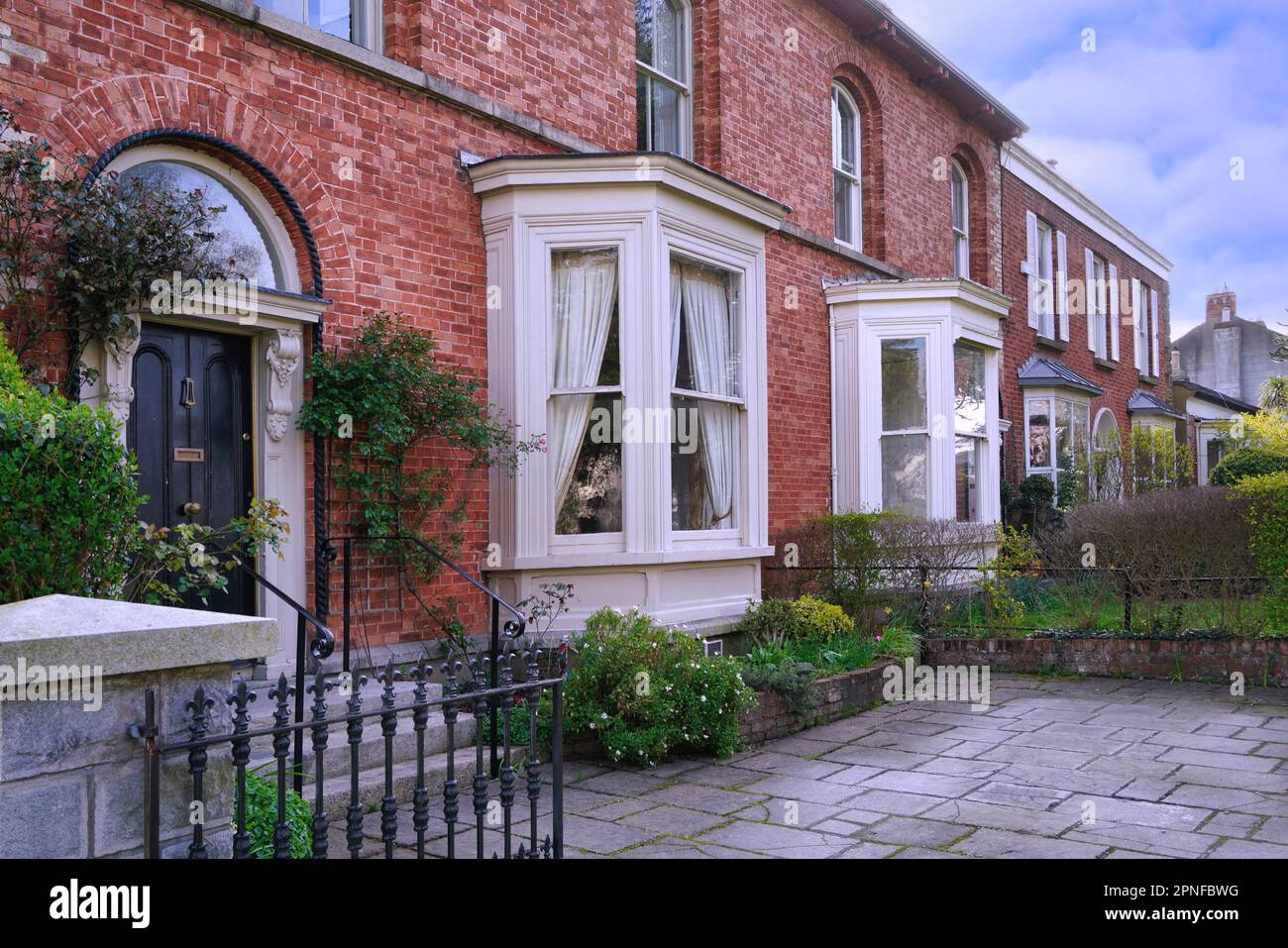 Row of elegant old brick townhouses with bay windows Stock Photo - Alamy