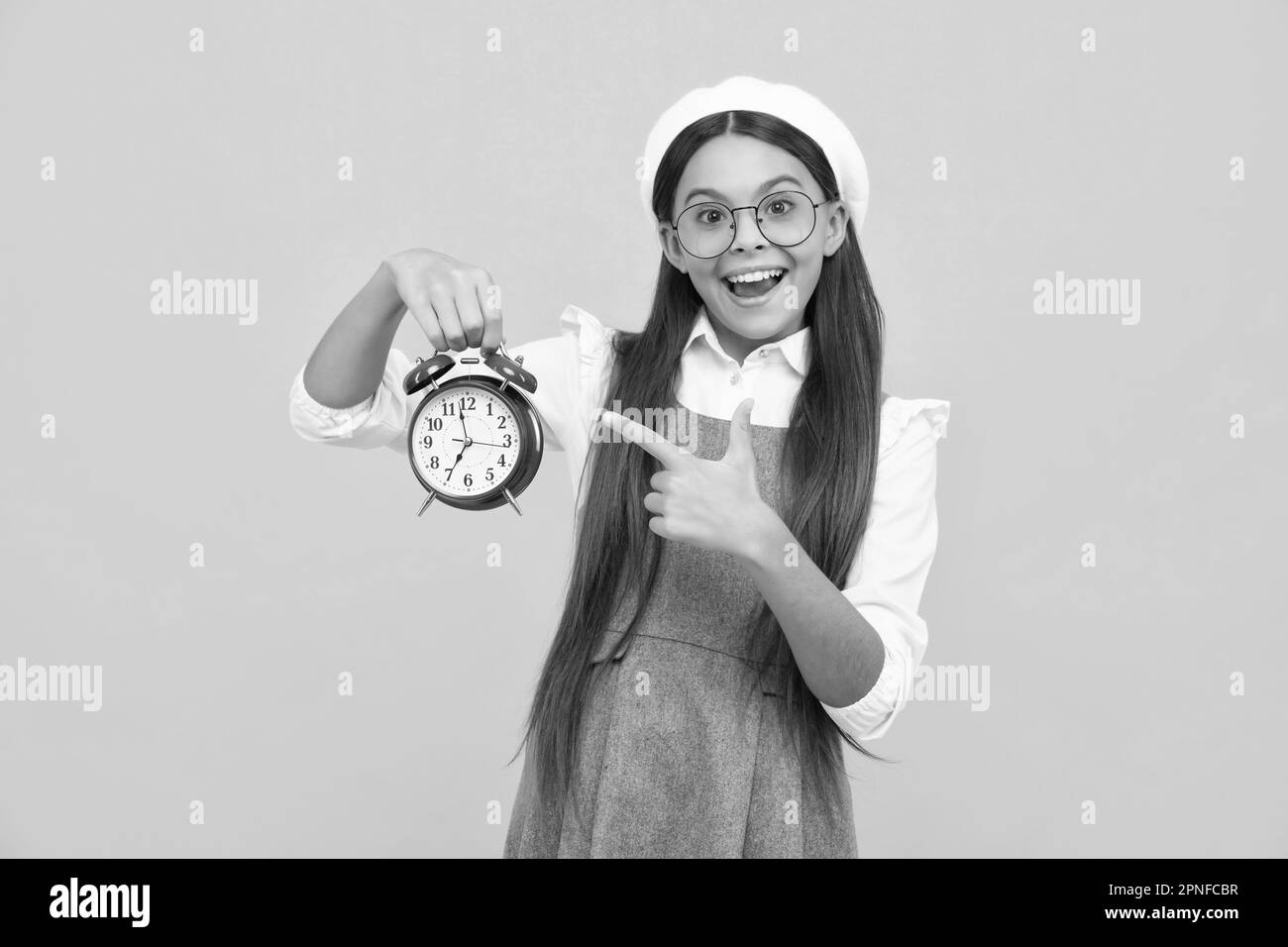 Portrait of teenage girl with clock alrm, time and deadline. Studio ...