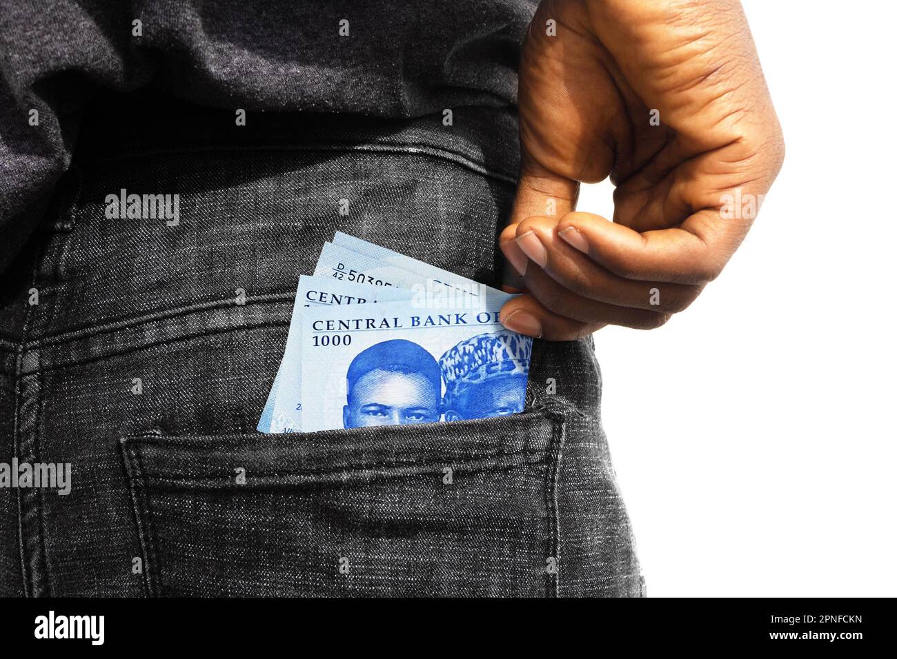 Black lady putting few Nigerian naira notes into her back pocket ...