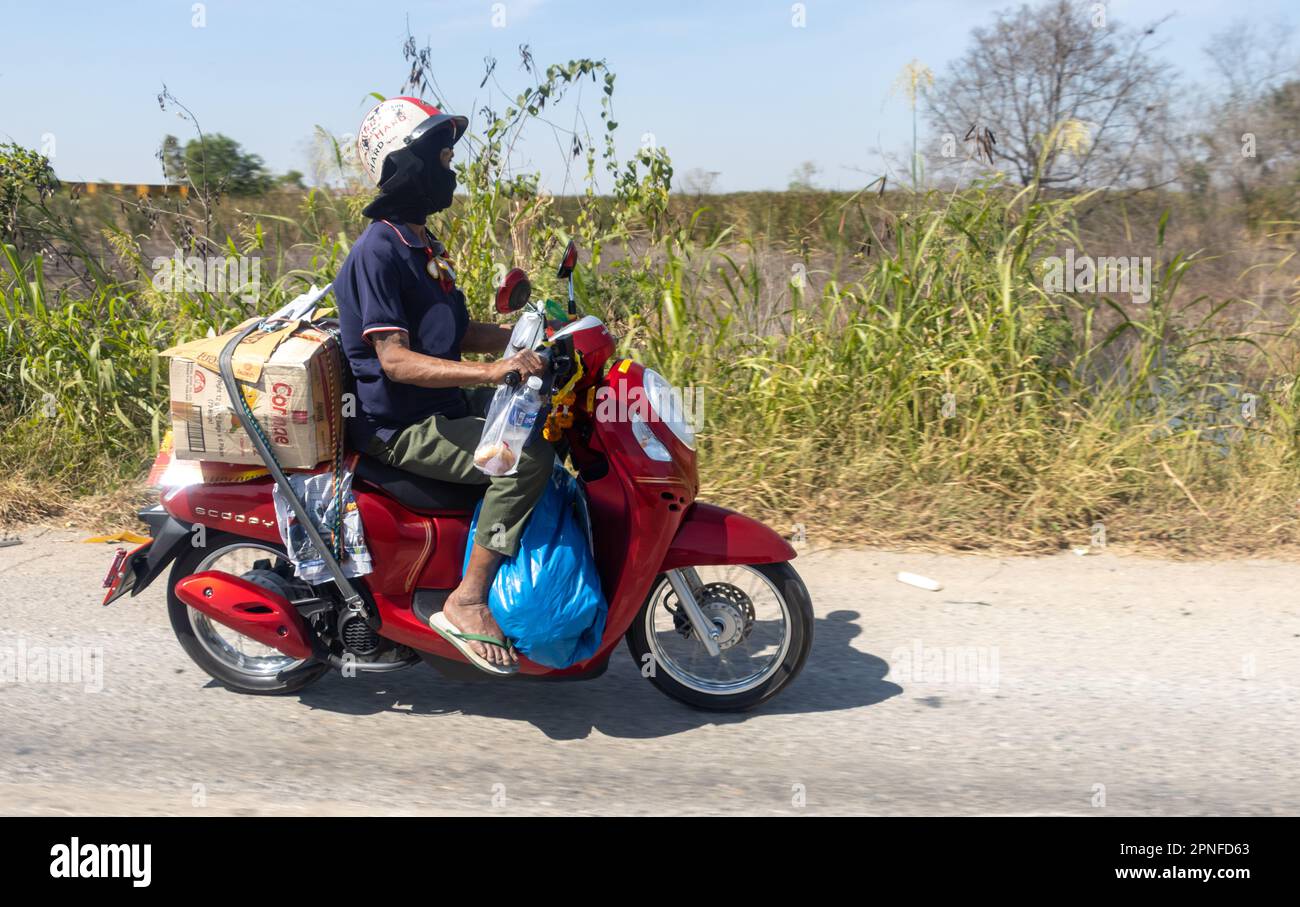 THAILAND, JAN 21 2023, A woman with load rides a motorcycle Stock Photo ...