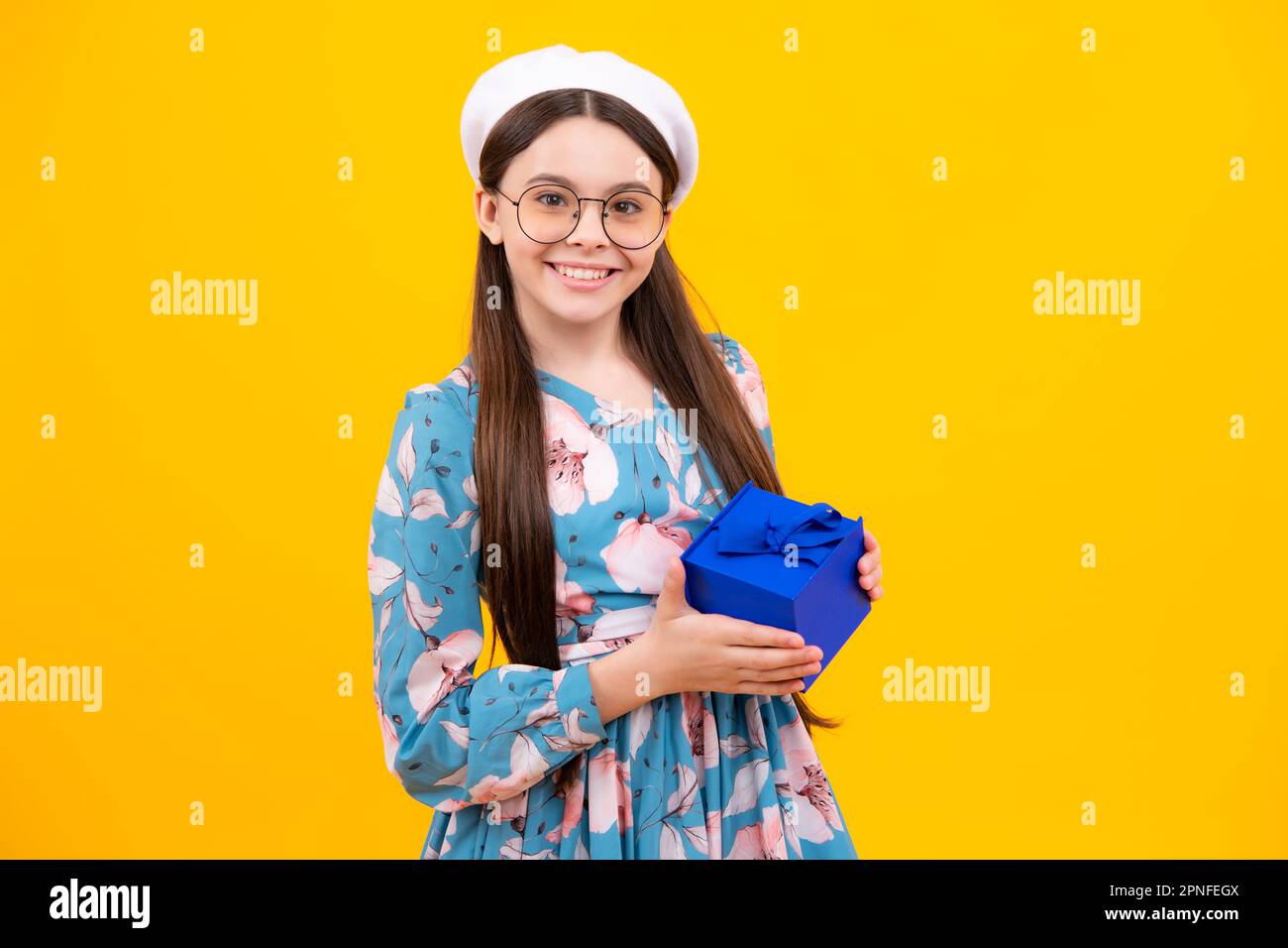 Child with gift present box on isolated studio background. Gifting for ...