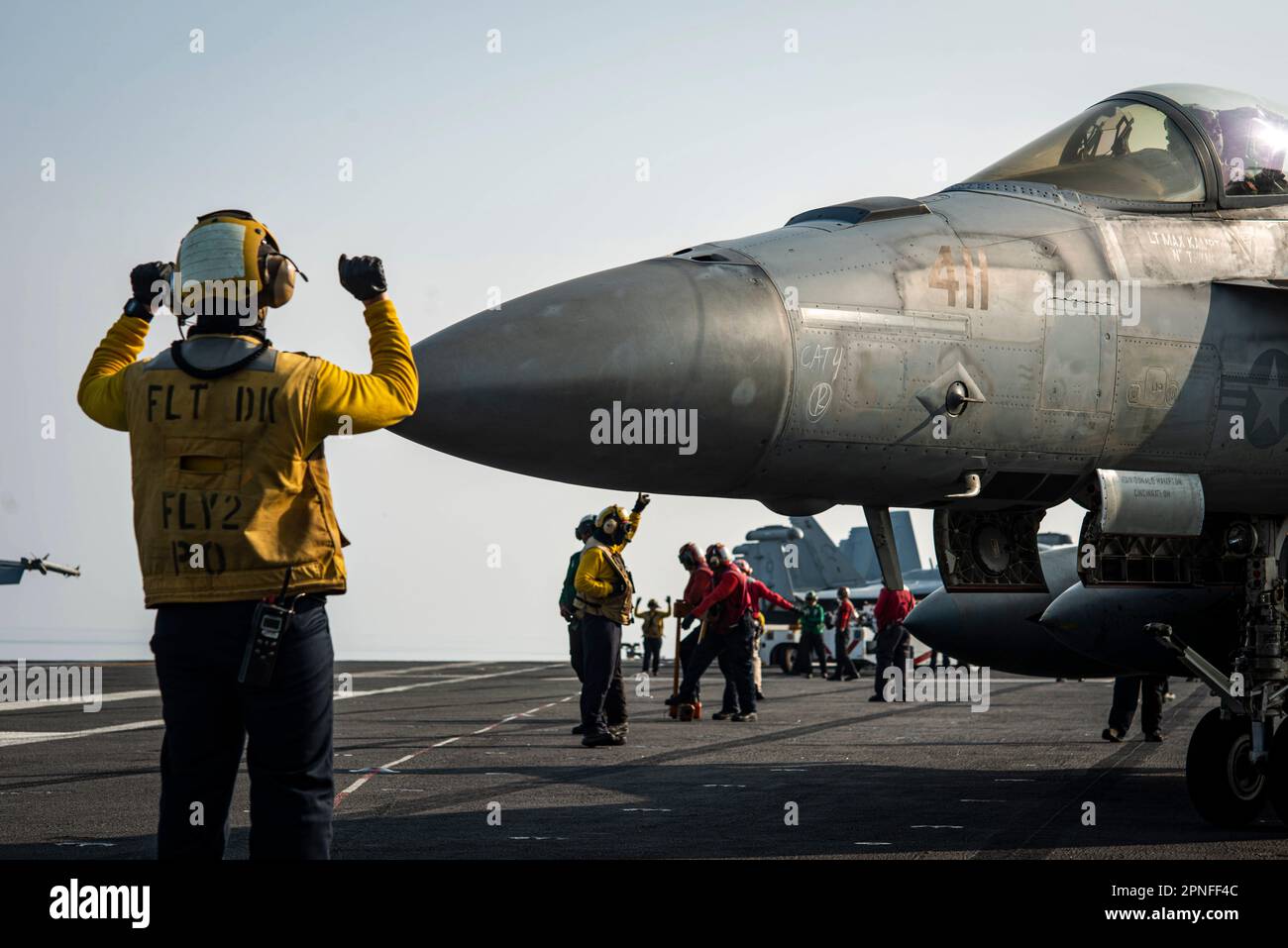 230417-N-XK462-1040 SOUTH CHINA SEA (April 17, 2023) A U.S. Navy Sailor directs an F/A-18E Super ...