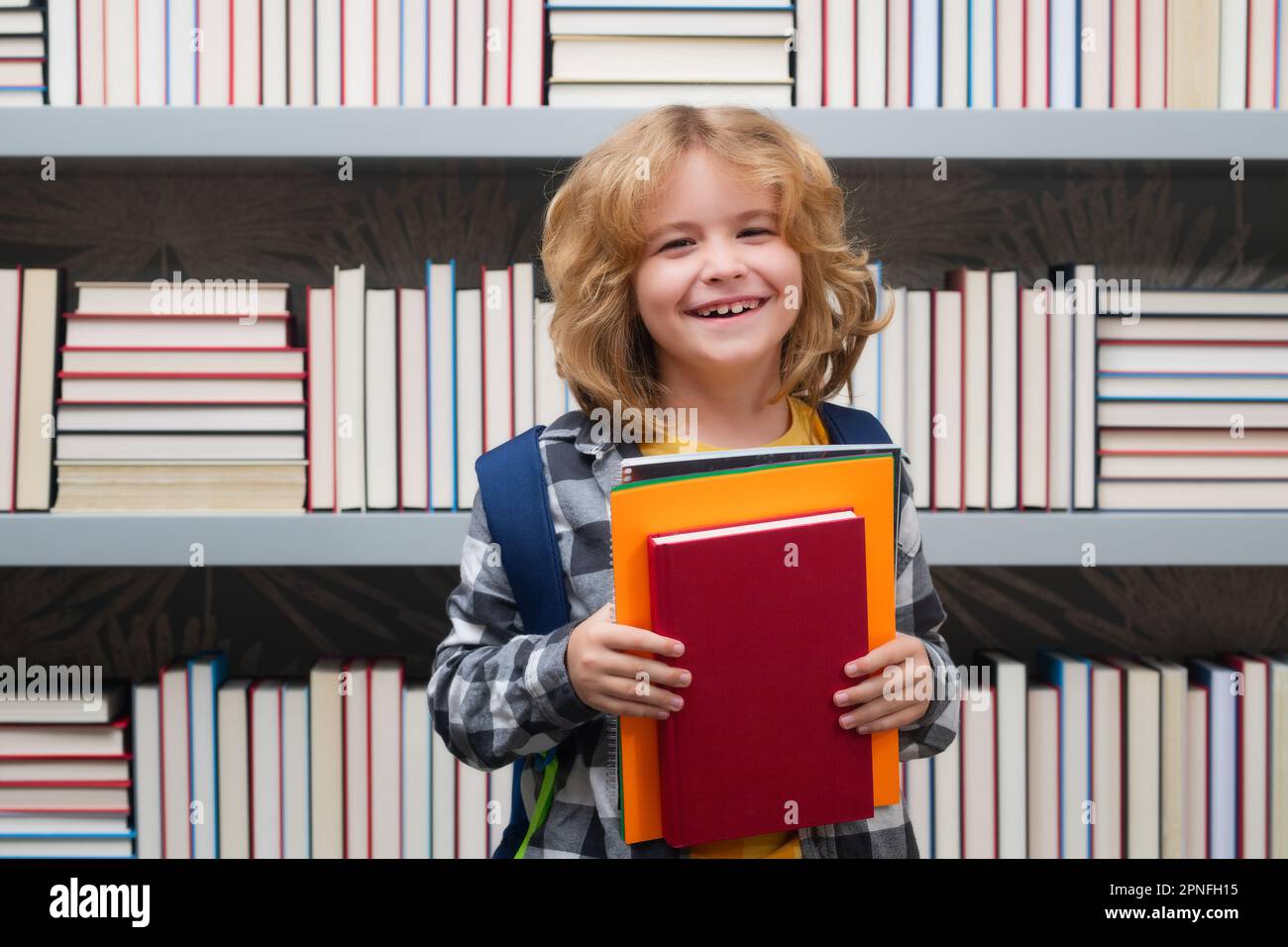 School boy with books in library. School kids. Child from elementary ...