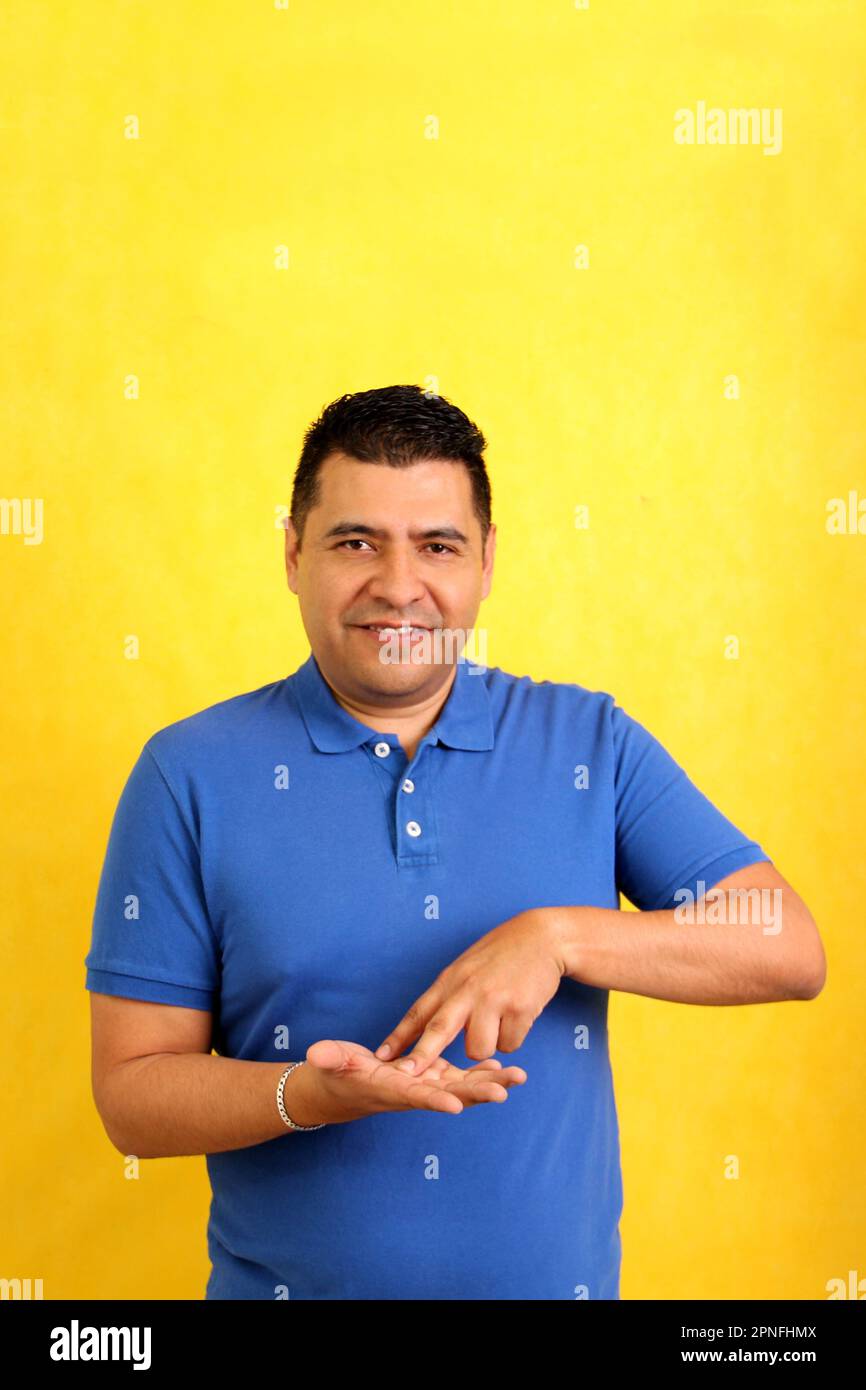 Dark-haired Latino adult man uses sign language typical of deaf people ...