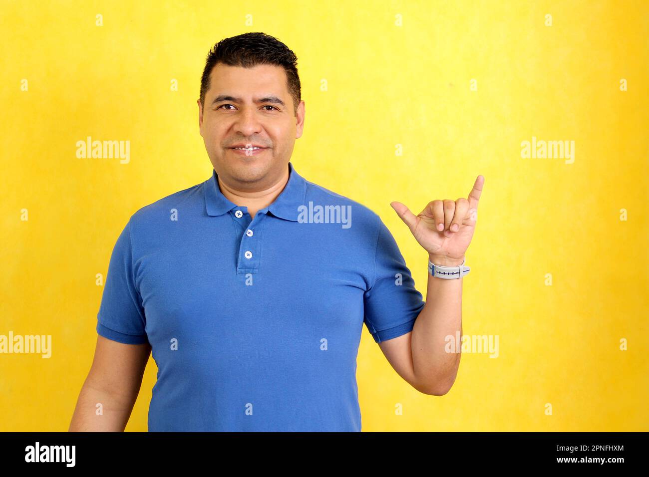 Dark-haired Latino adult man uses sign language typical of deaf people ...