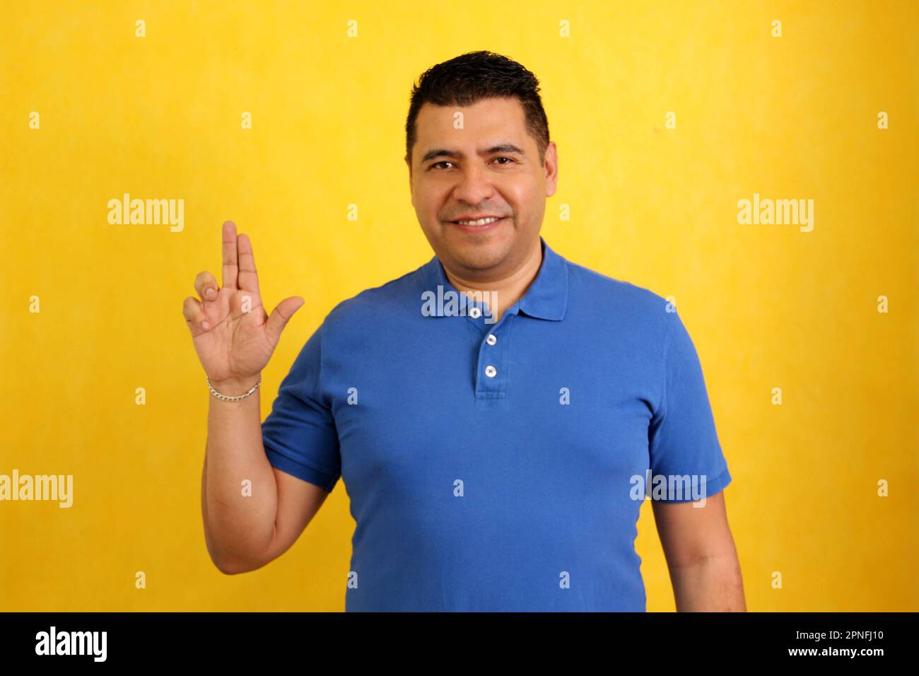 Dark-haired Latino adult man uses sign language typical of deaf people ...