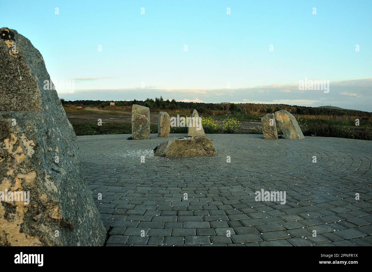 An ancient round stone sanctuary lined with paving slabs on top of a ...