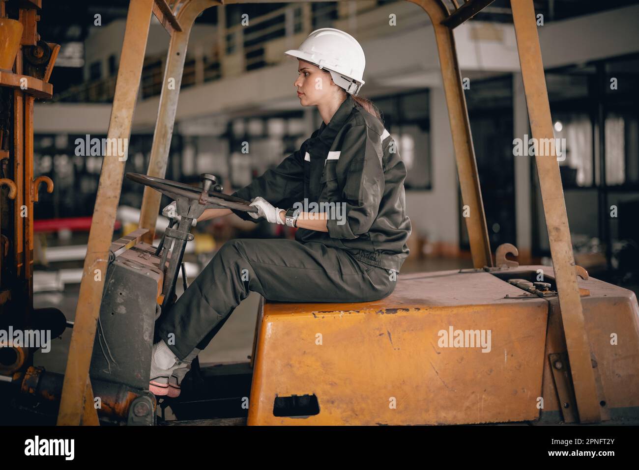 A female robotic technician operates the folklift and schedules regular ...