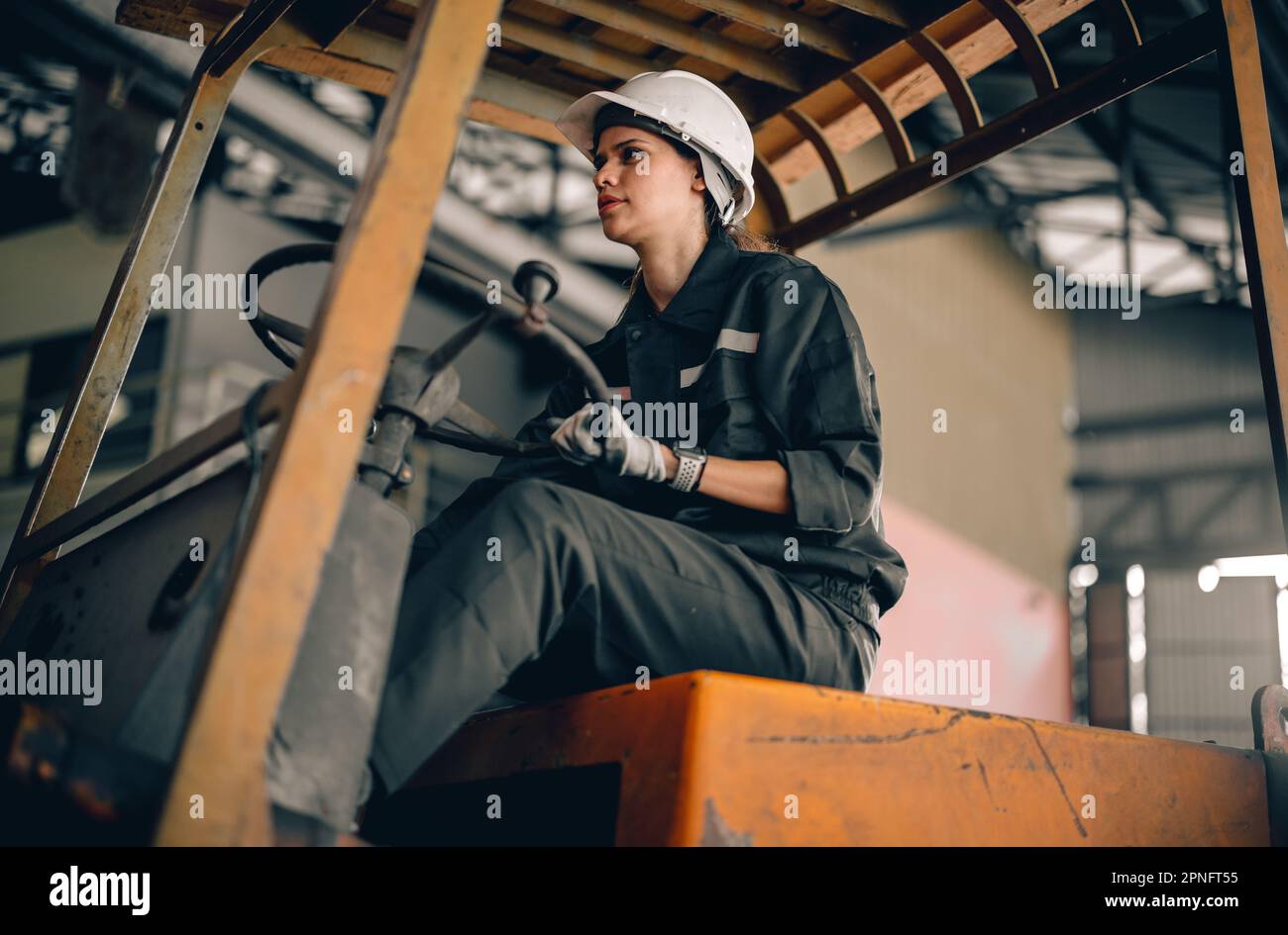 A female robotic technician operates the folklift and schedules regular ...
