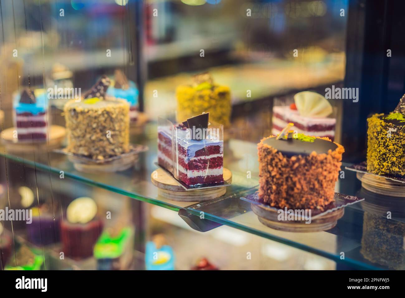 Different types of cakes in pastry shop glass display Stock Photo - Alamy