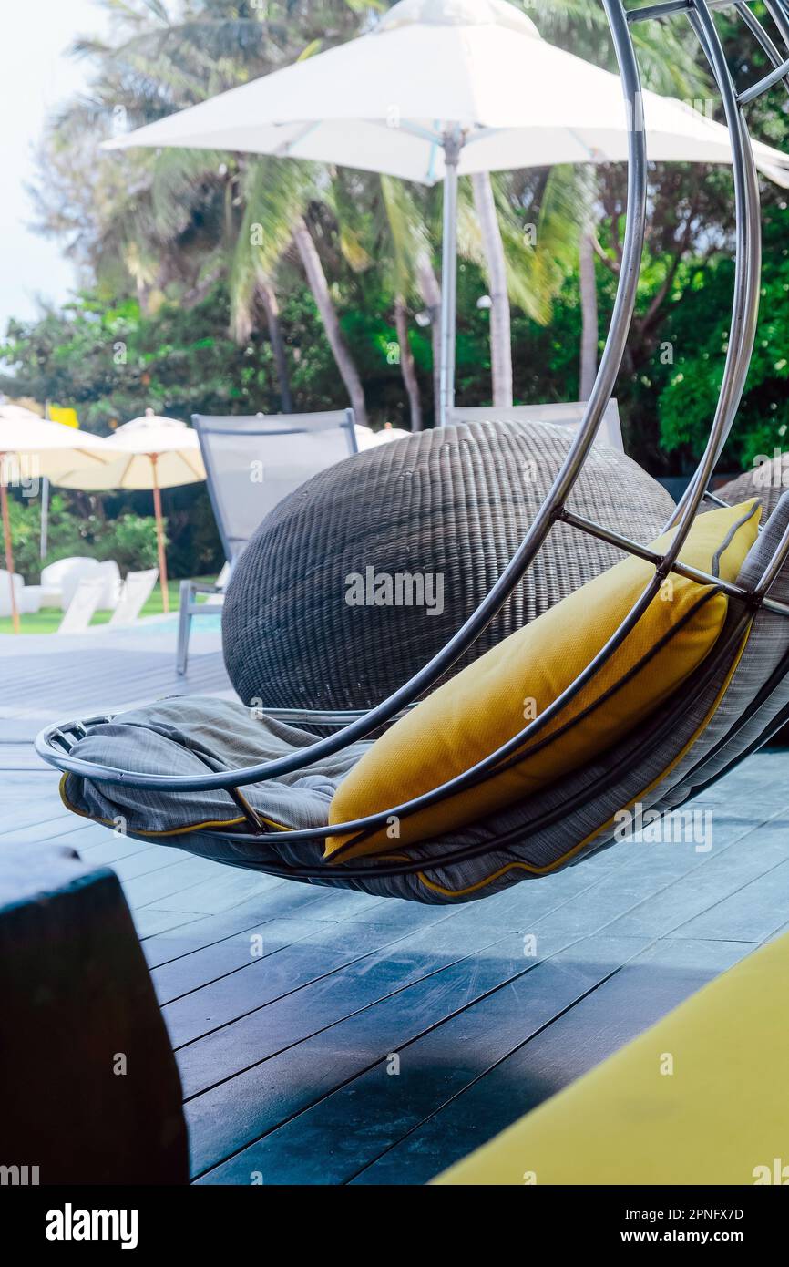 Image of Relaxing chairs with pillows beside swimming pool Stock Photo ...