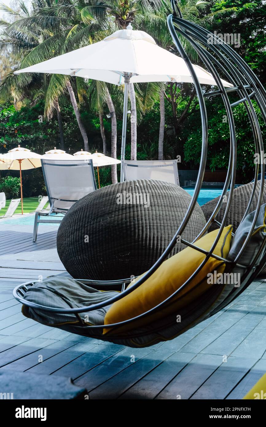 Image of Relaxing chairs with pillows beside swimming pool Stock Photo ...
