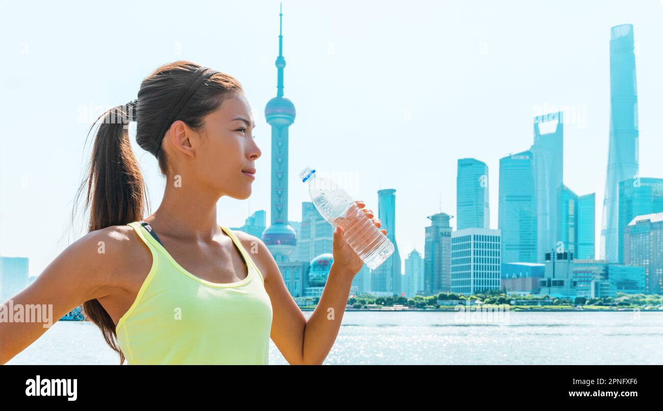 Healthy active lifestyle runner girl drinking water bottle at Shanghai ...