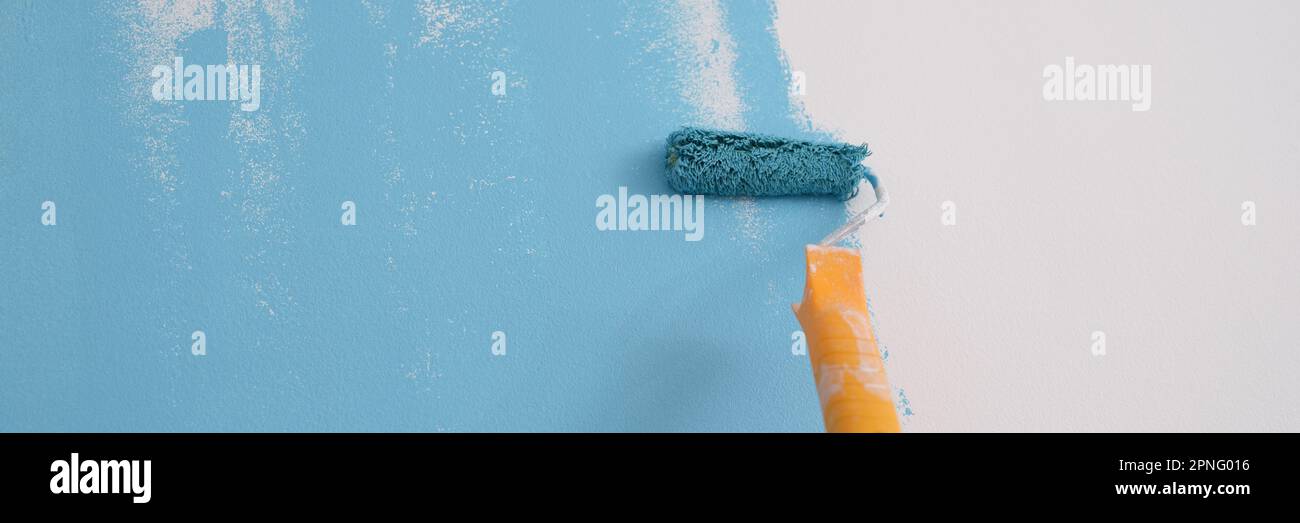 Professional decorator painting wall in blue color Stock Photo - Alamy