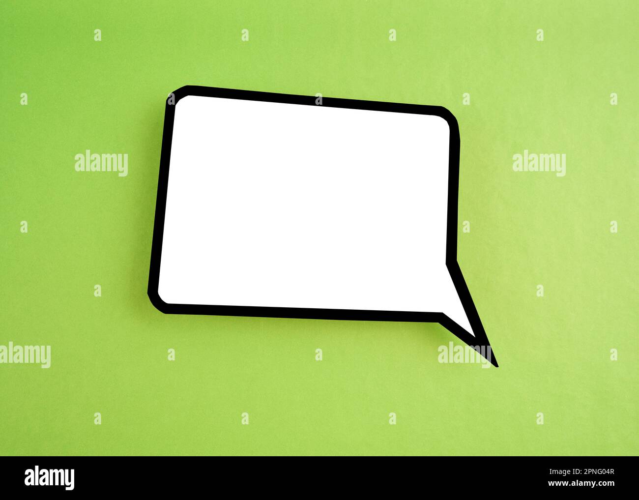 White speech bubble shaped post it note on green background with copy ...