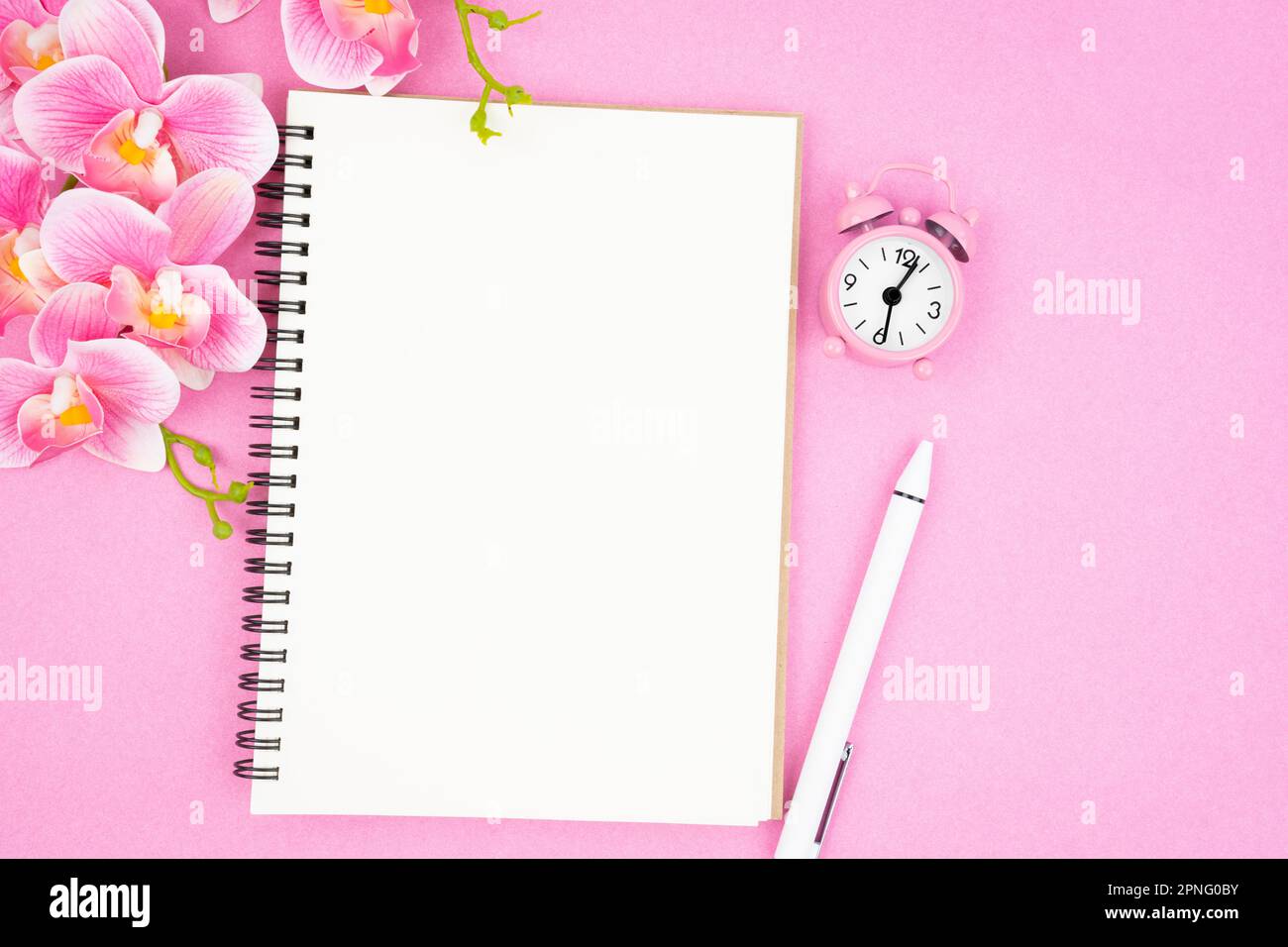Blank open notebook and clock with pink color orchid for your text or message Stock Photo - Alamy