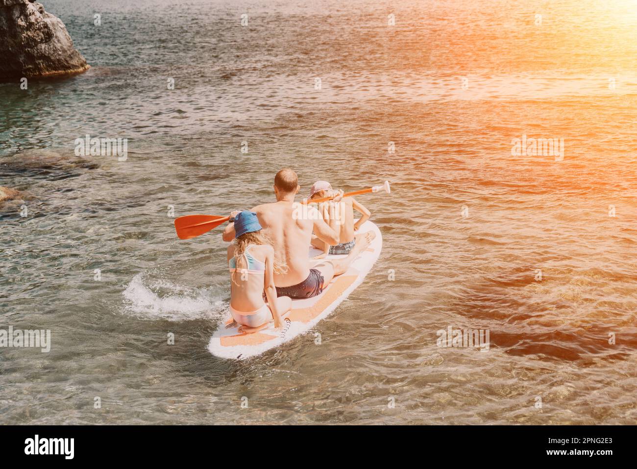Family sea sup. Young happy father with his son and daughter Floating ...