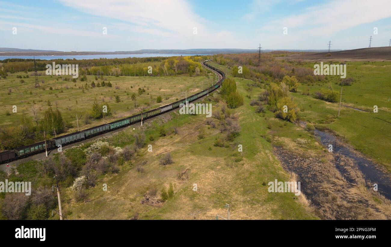 Aerial view of a freight train delivering cargo through a picturesque ...