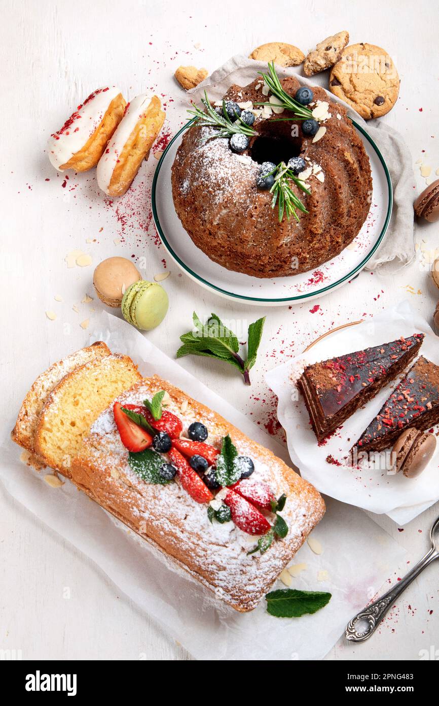 Dessert table with various of bundt cakes, pieces of cakes, sweets ...