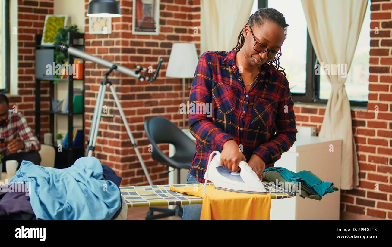 Depressed african american woman ironing laundry, getting angry at ...