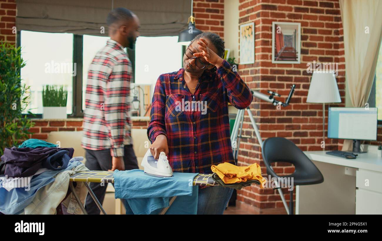 Dissatisfied african american adult does domestic chores without help ...