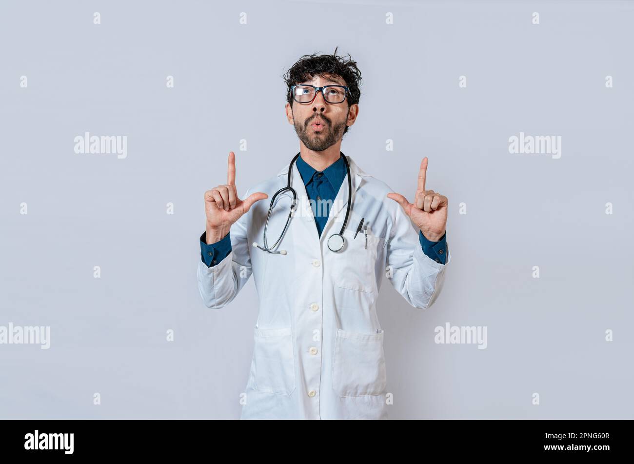 Surprised doctor pointing up. Amazed doctor pointing a promo up. Male ...