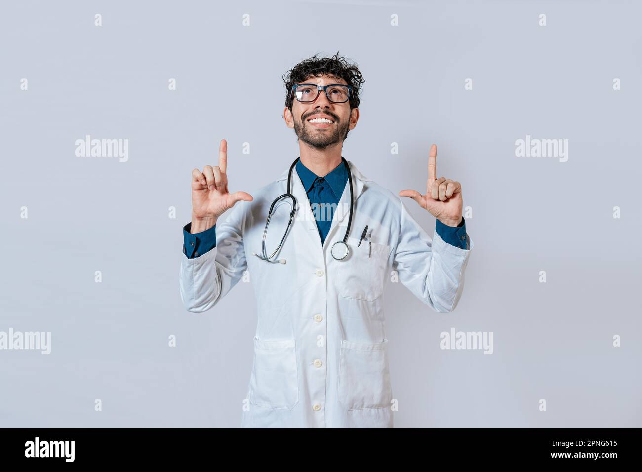 Handsome doctor pointing up. Smiling doctor pointing a promo up. Male ...