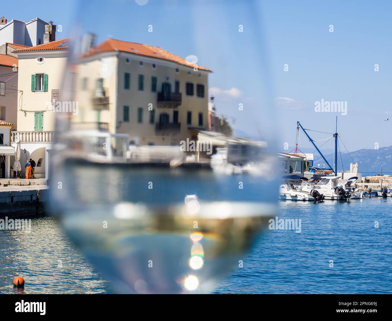 View through a wine glass, fishing village Valun, island Cres, Croatia ...