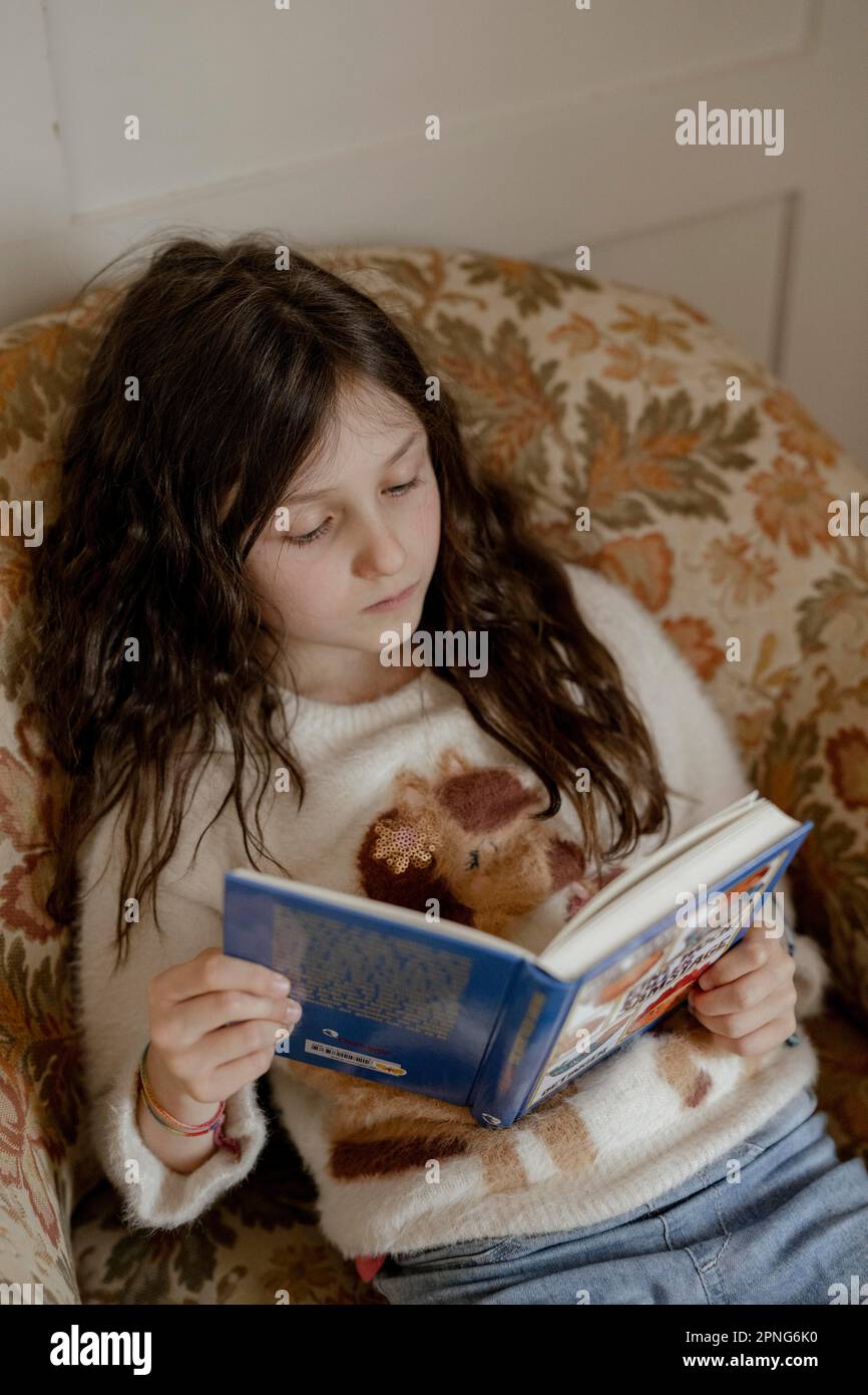 Girl, 8 years, reading a children's book Stock Photo - Alamy