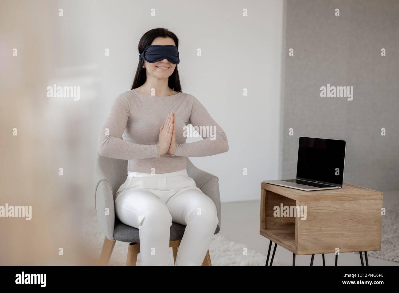 Woman sitting on chair doing a relaxation exercise Stock Photo - Alamy