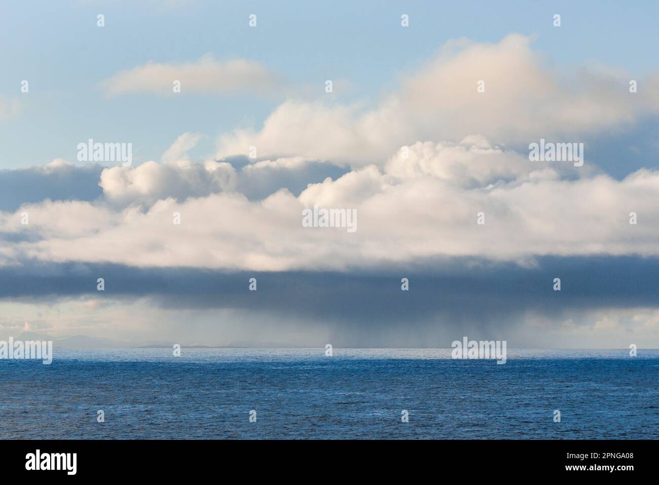 Low-lying rain clouds drift over the open waters of the blue Atlantic ...