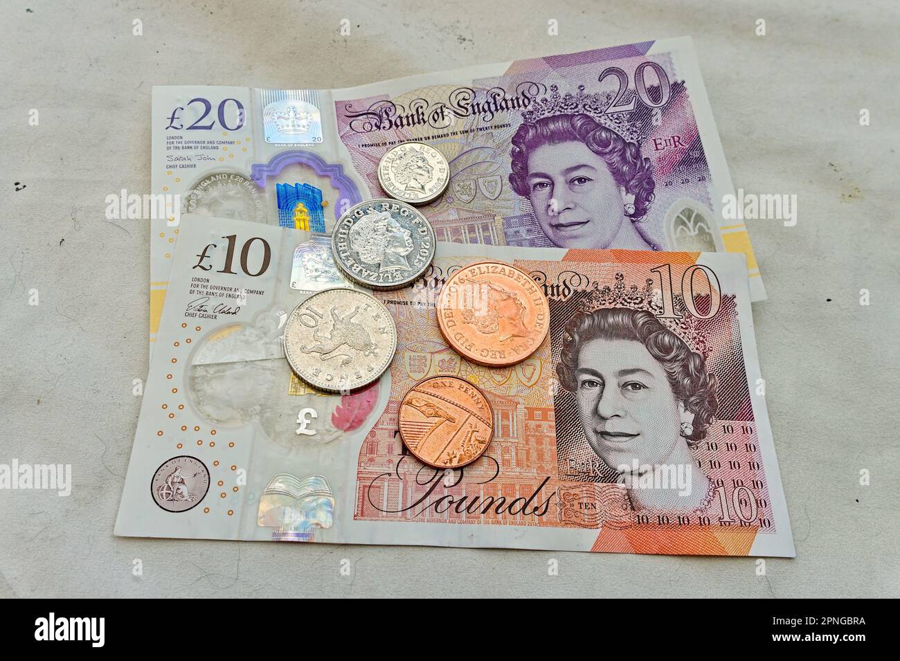 Ten and twenty-pound British banknotes & coins featuring the late queen ...