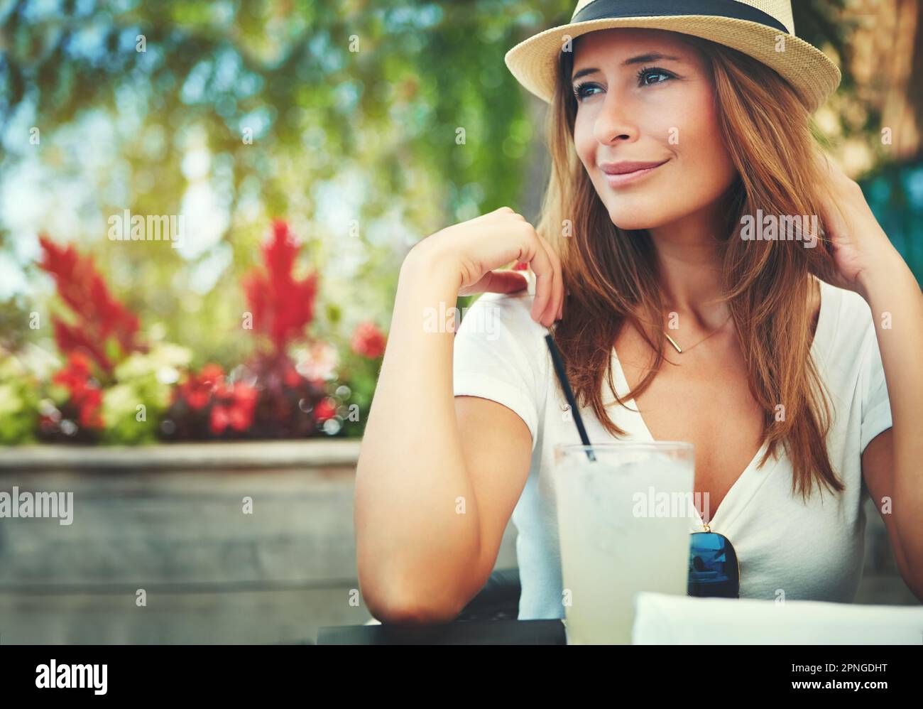Embracing the day to the fullest. a cheerful young woman wearing a hat ...