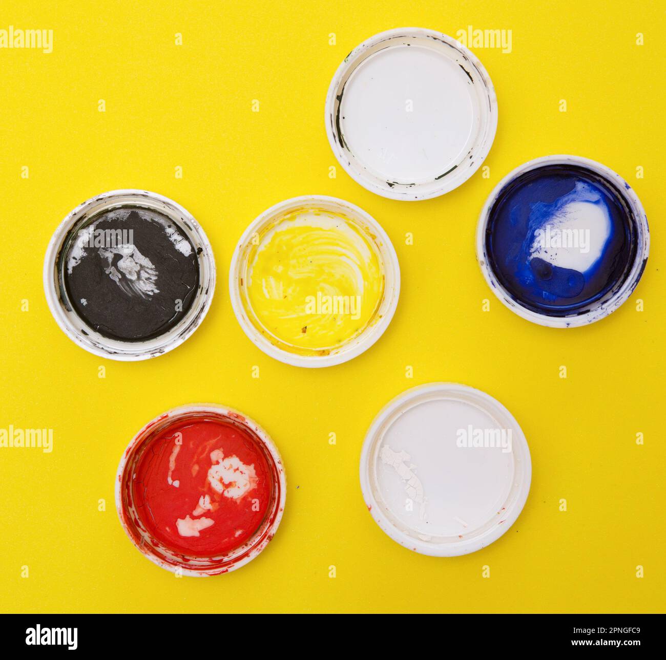 Colored lids on yellow. Top view Stock Photo - Alamy
