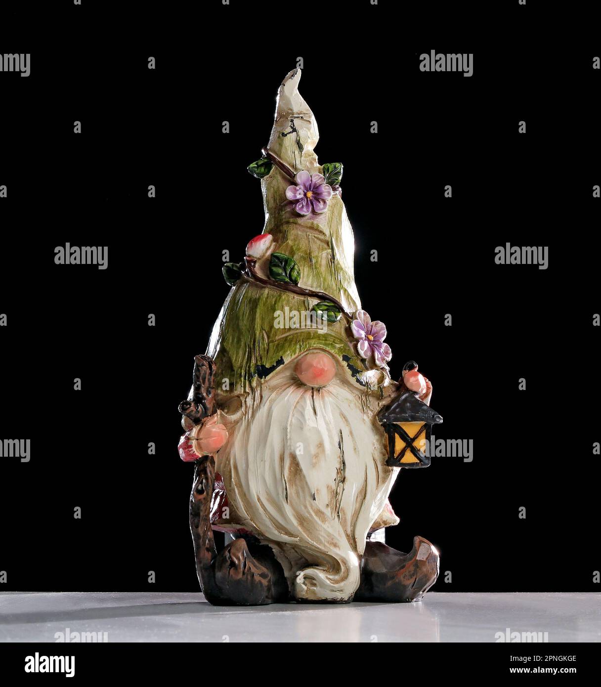 A ceramic wizard garden gnome on a black background Stock Photo - Alamy