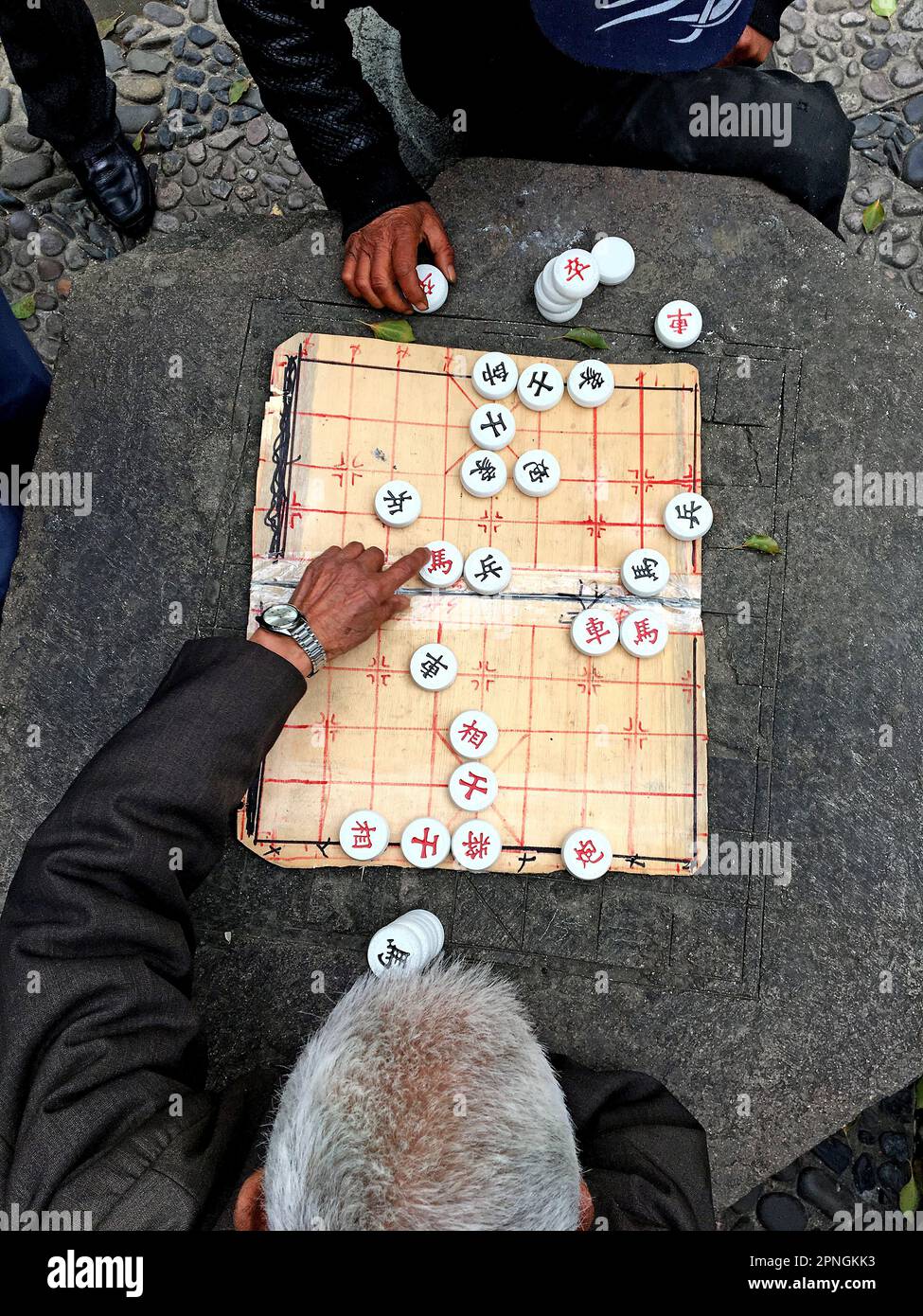 An overhead shot of two Asian men playing a game of xiangqi, a ...