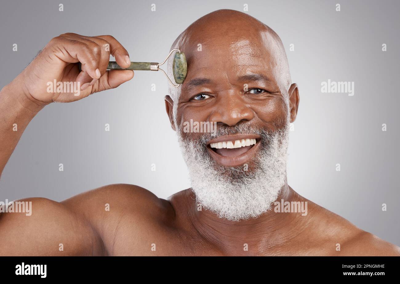 Face roller, portrait and senior black man with skincare smile, stone ...
