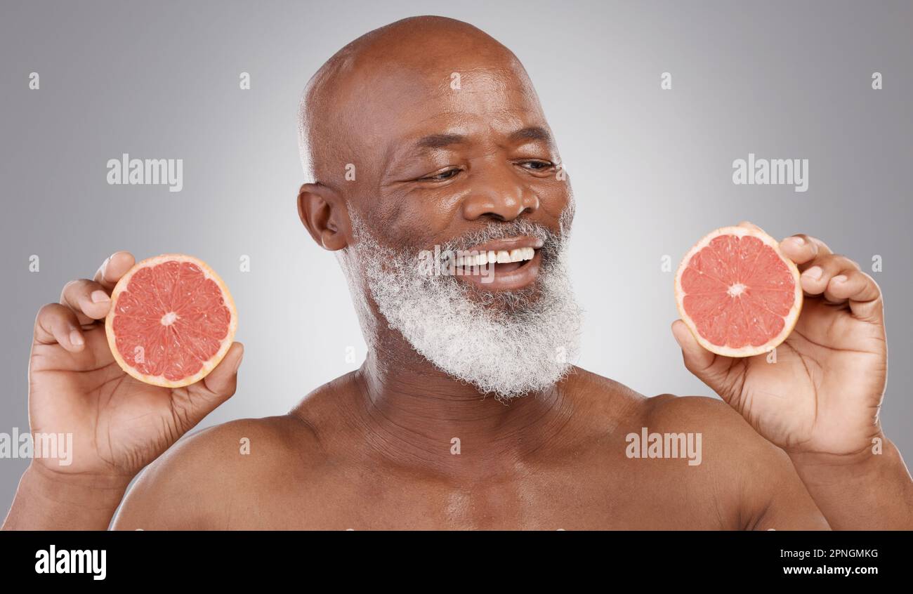 Senior black man, grapefruit and smile for skincare, natural nutrition or vitamin c against a ...