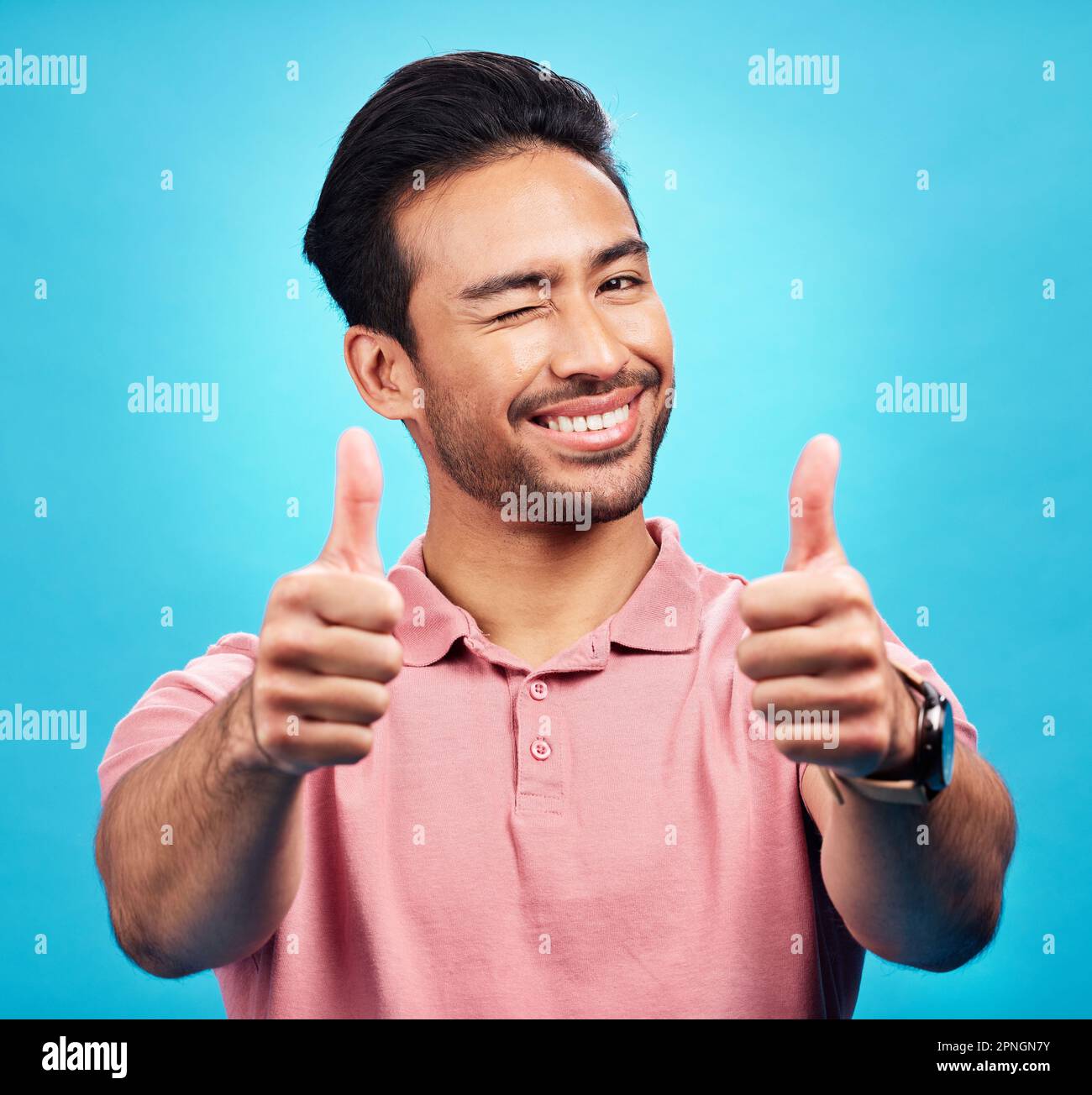 Portrait, thumbs up or wink by man in studio in positive, feedback or ...