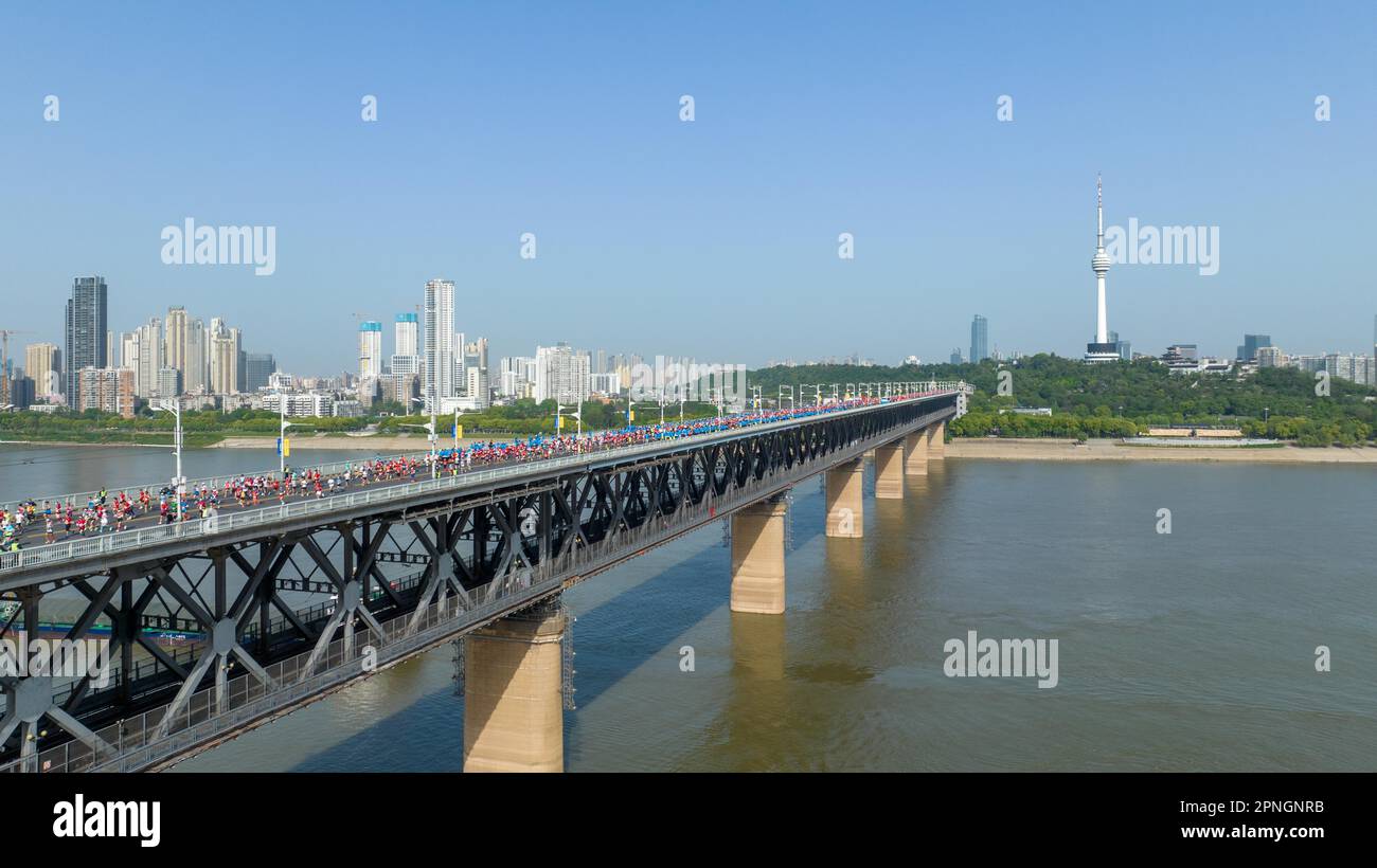 Aerial photo shows runners passing the Wuhan Yangtze River Bridge ...